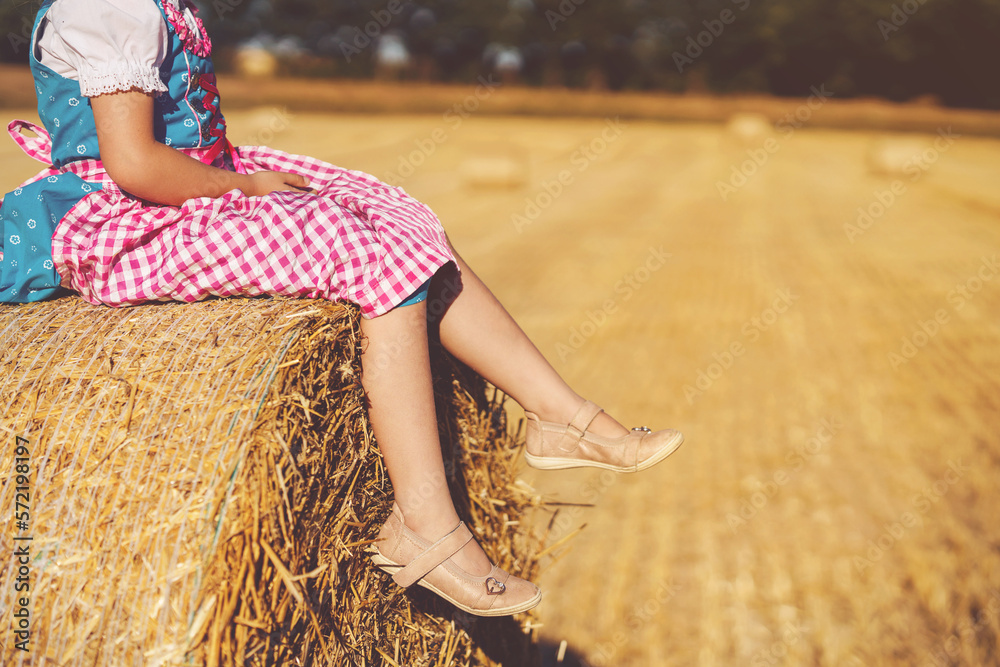 Cute little kid girl in traditional Bavarian costume in wheat field ...