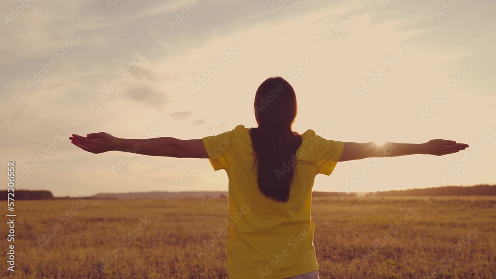 young girl catches glare sun with her hand outside. outdoor meditation ...