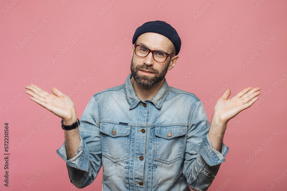 Foto de Portrait of hesitant bearded male with doubtful expression ...