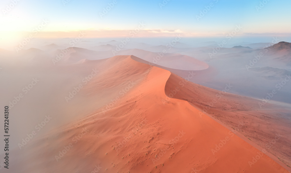 Orange Sand Dunes of the Namib Desert lit by sunrise: Aerial, panoramic ...