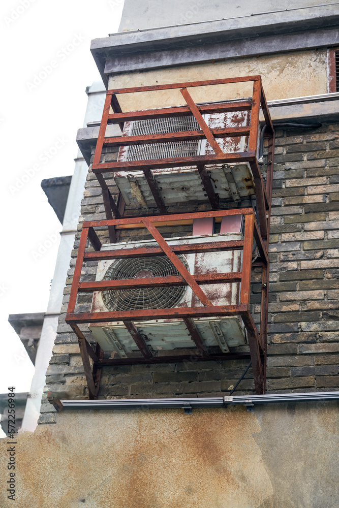 Close-up of an air conditioner outdoor unit installed outside an old ...