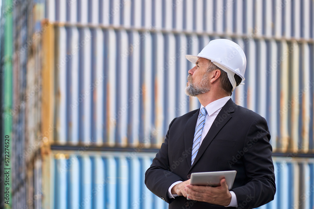 A single engineer manager in black suit and safety helmet use tablet to ...