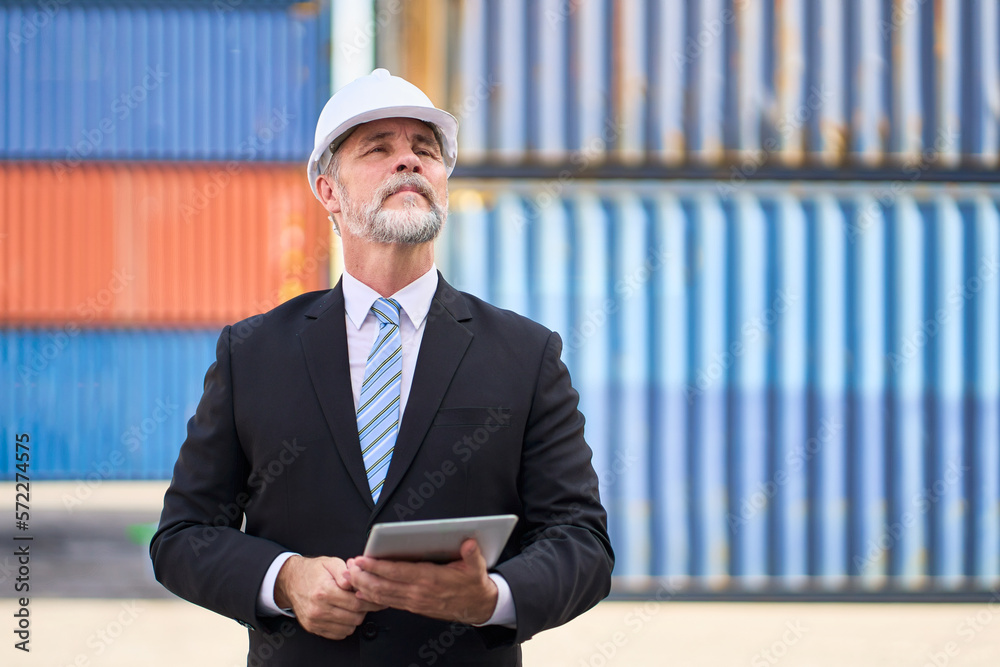 A single engineer manager in black suit and safety helmet use tablet to ...
