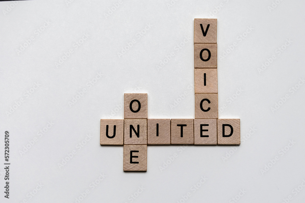 united with one voice spelled out using wooden tiles with letters on ...