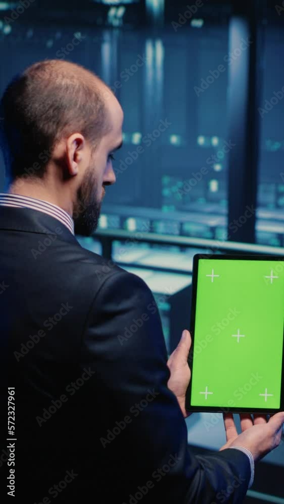 Vertical video: Data center technician holding tablet with green screen ... Vertical video: Data center technician holding tablet with green screen ...