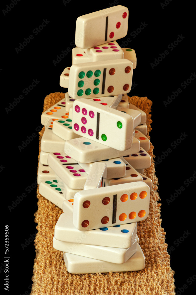 See a closeup of a stack of dominoes piled high and up on end so that ...
