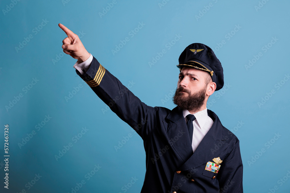 Serious captain pointing at sky with index finger, wearing professional ...