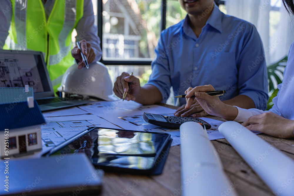 Foto de Civil engineer team meeting with helmet and typing in house ...