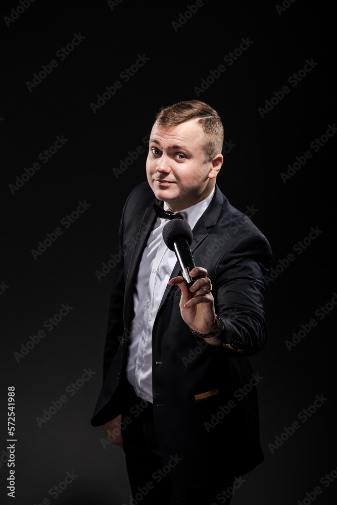 Portraite of man with microphone who posing on dark background, actor ...