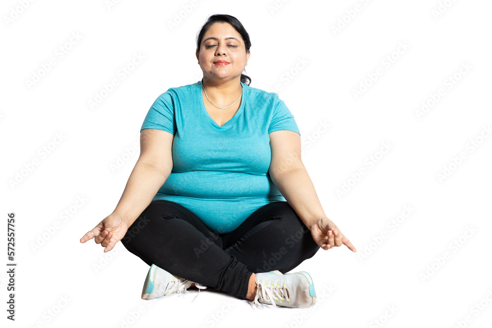 Fat indian woman doing meditation yoga exercise while siting on floor ...