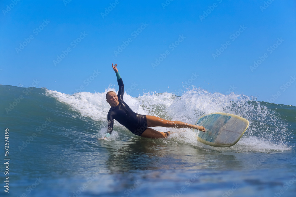 Female surfer falling off surfboard while riding wave, Male, Maldives ...