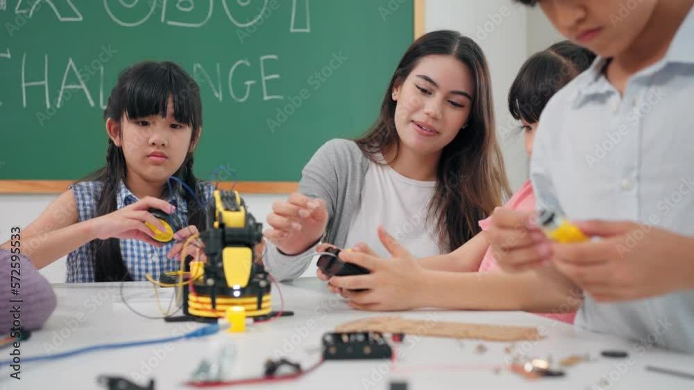 Elementary students learning robot class together in science classroom ...