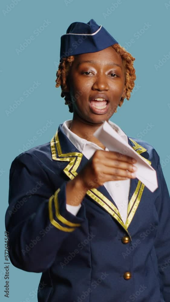 Vertical video: Female model showing folded airplane in studio, playing ...