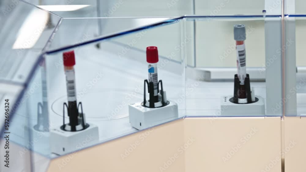 Side view of blood samples and empty test tube's holders moving on a ...