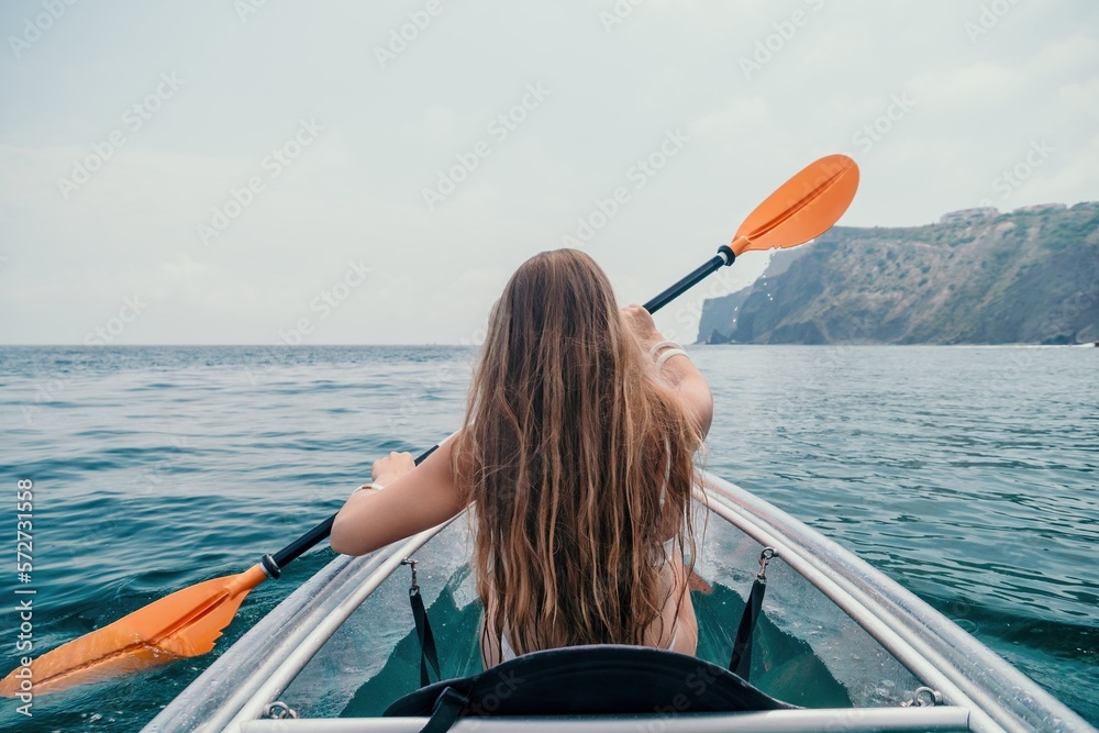 Woman in kayak back view. Happy young woman with long hair floating in ...