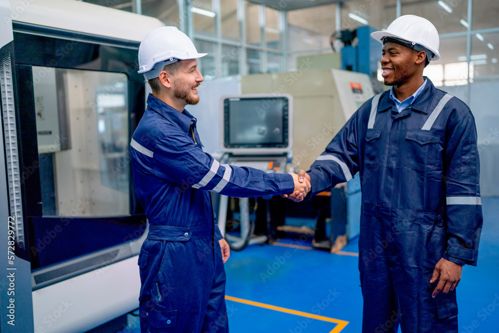 Caucasian worker and African American technician shake hand with ...