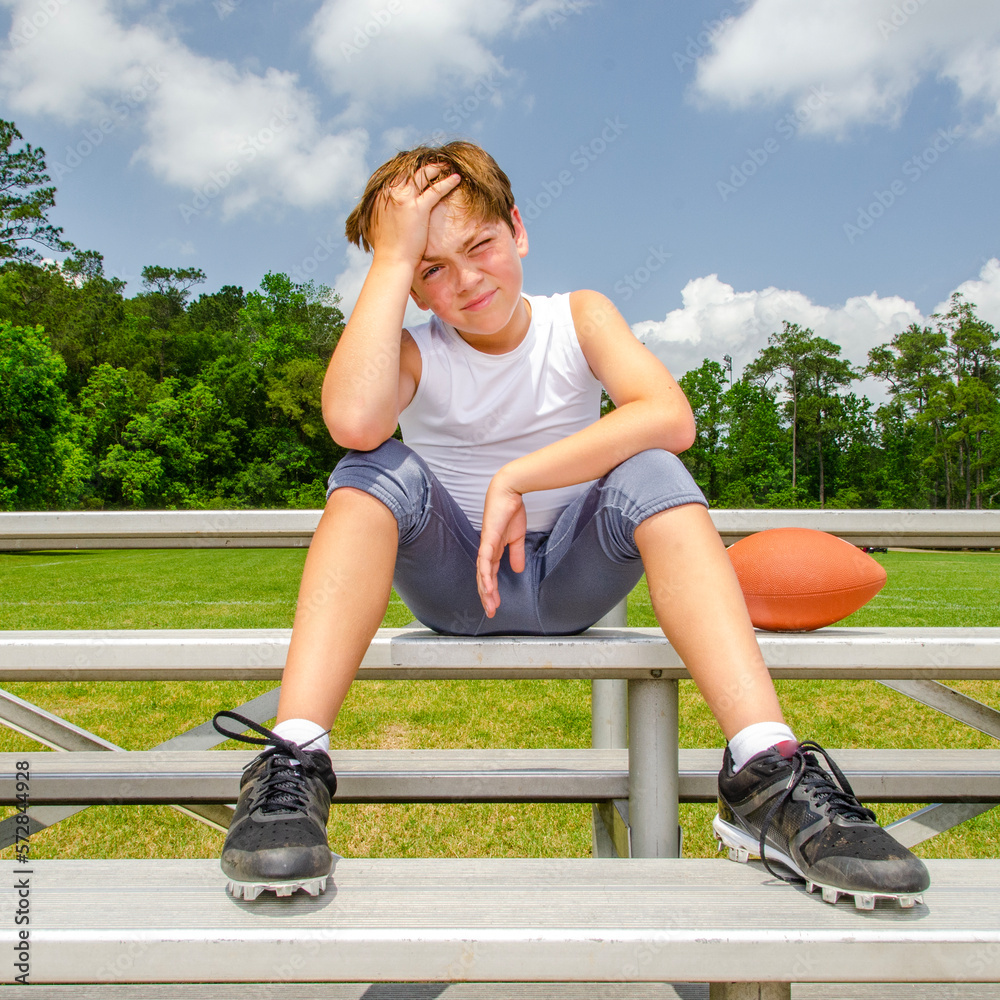Youth Preteen Boy Football Player Sitting on the Bleachers with ...