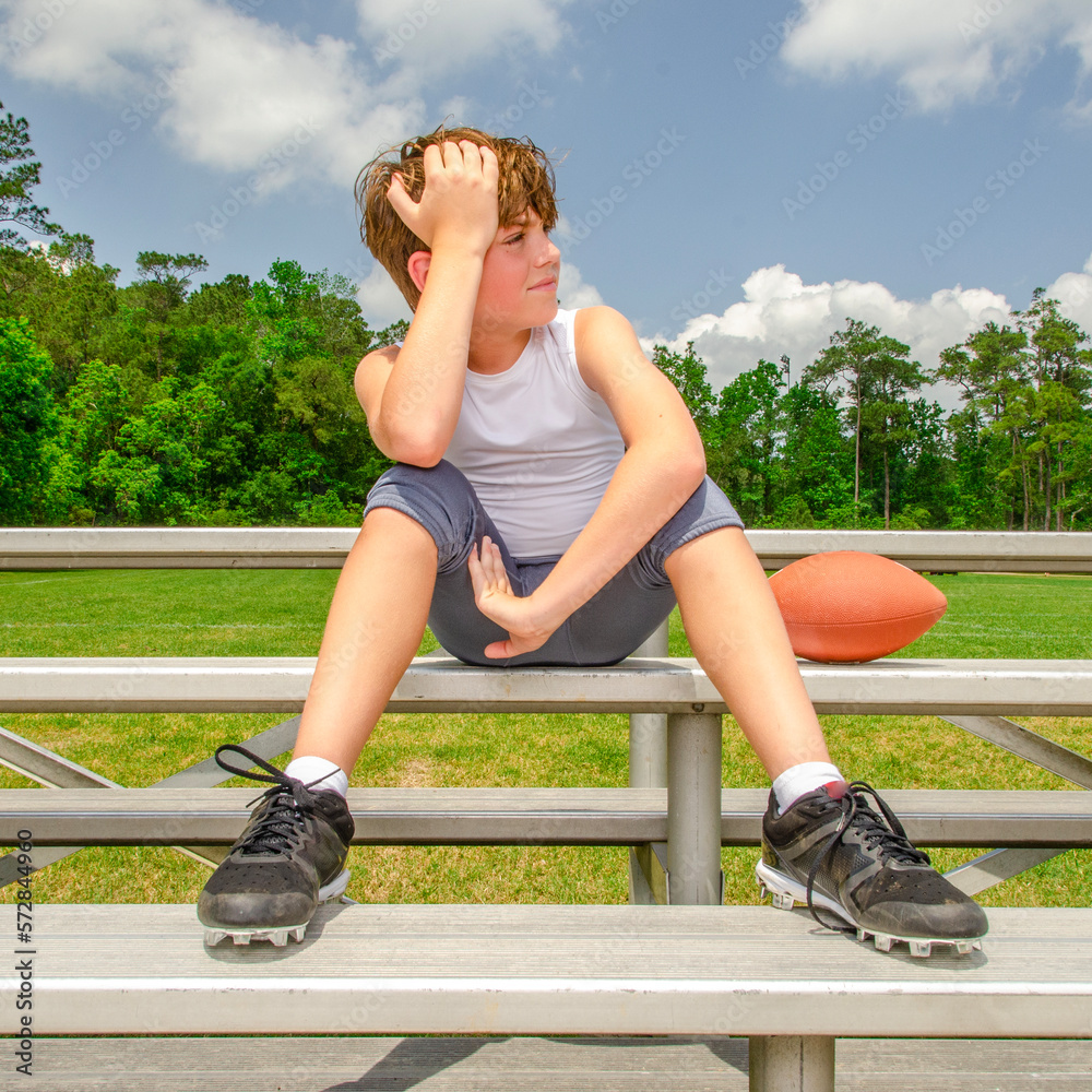 Youth Preteen Boy Football Player Sitting on the Bleachers with ...
