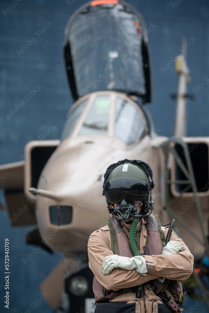 Fighter pilot standing with Military fighter Jet wearing flying helmet ...