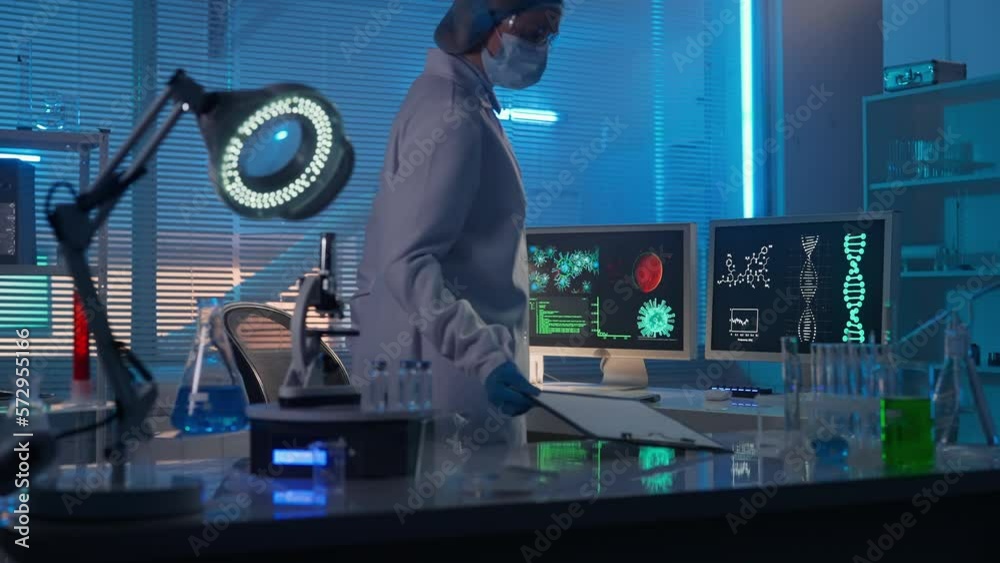Medical development laboratory. A female scientist types on a keyboard ...