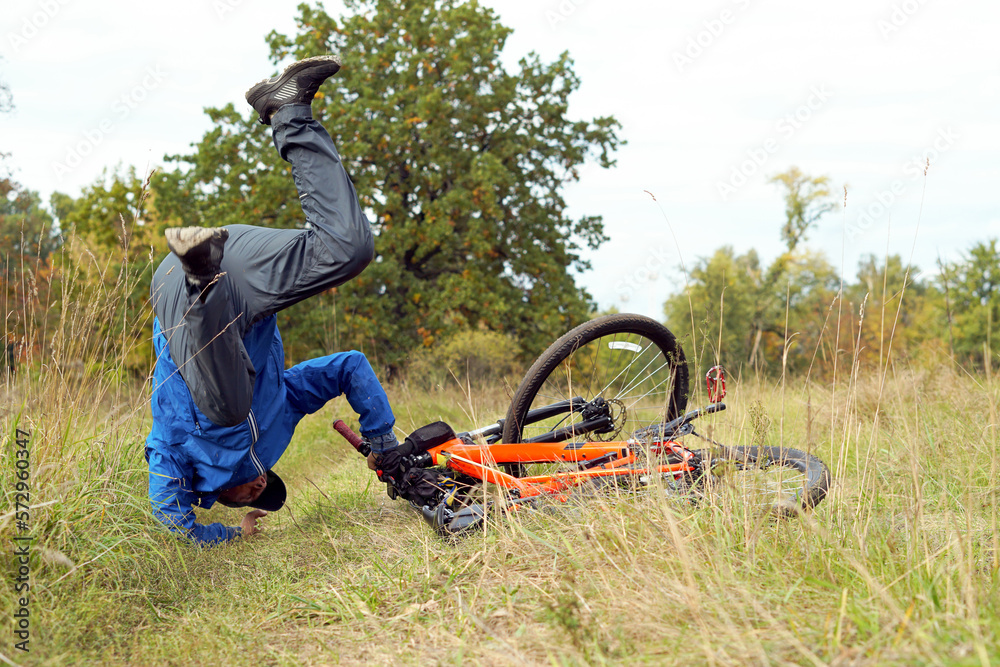 Stressed male cyclist falling from a bicycle fter a bad accident. Young ...
