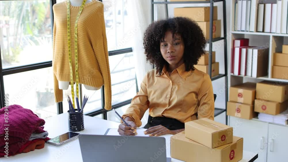African fashion designer girl working on her design in studio. Stock ...