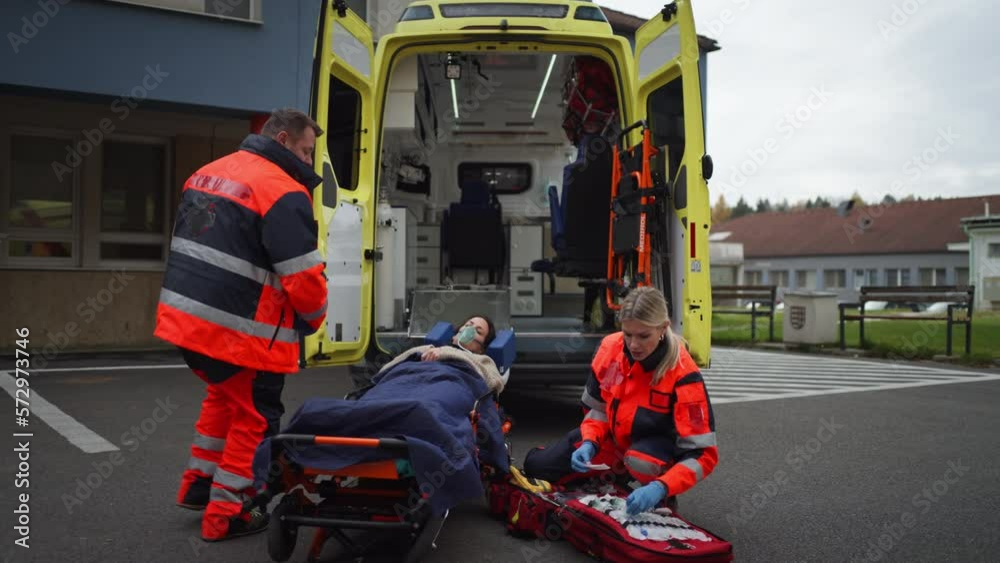 Rescuers taking care of patient, preparing her for transport. Stock ...