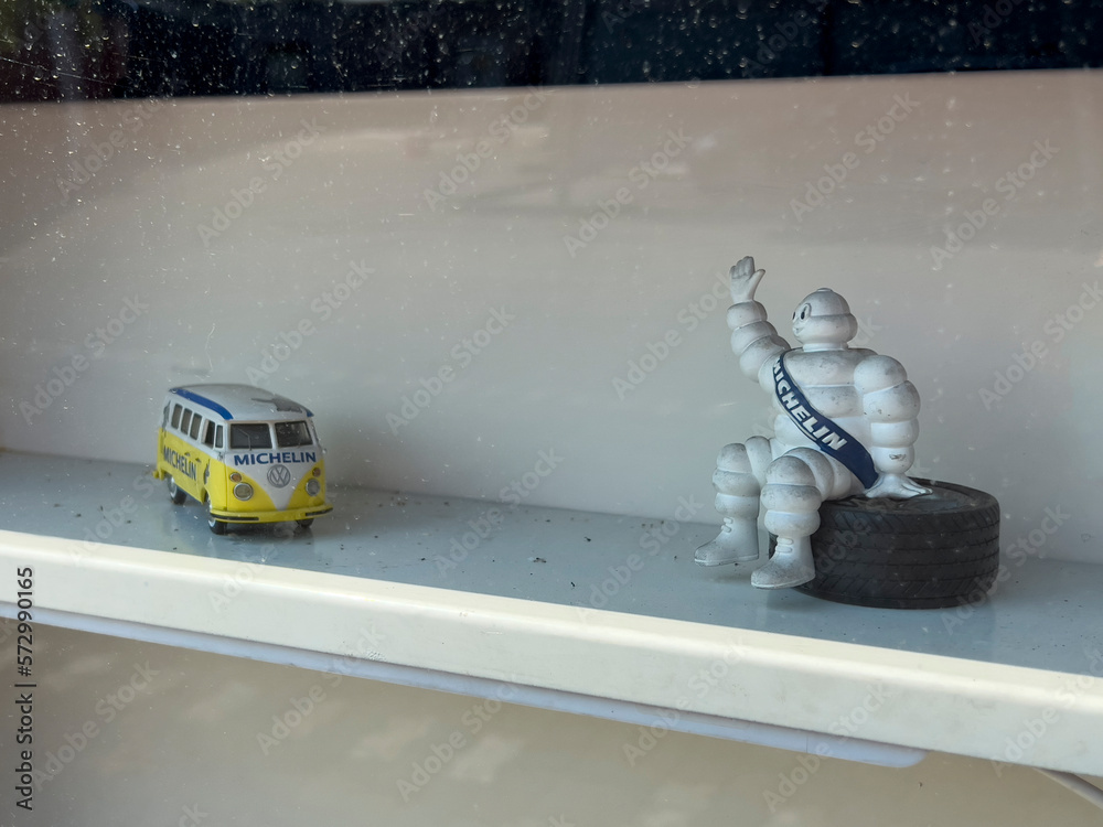 Michelin man sitting on a tire and an old Michelin VW bus in an old ...