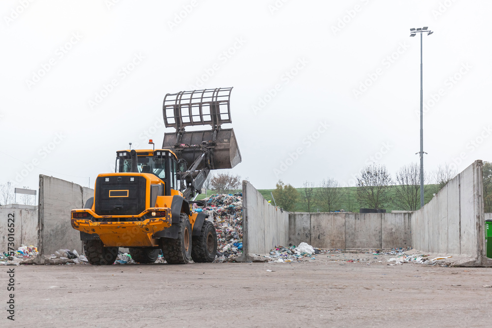 Front loader with scrap handling grapple bucket moving forward and ...