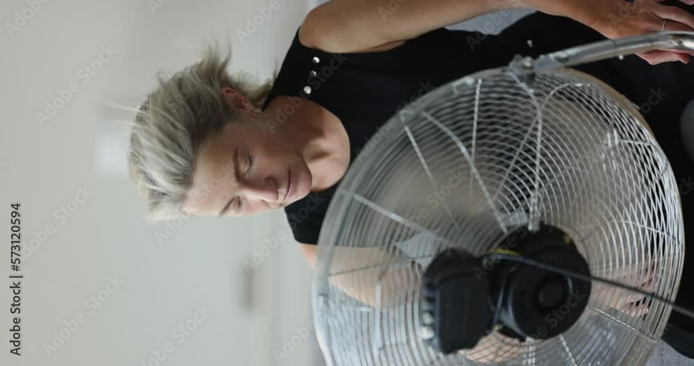 Middle-aged woman exhausted by unbearable heat, cooling herself using ...