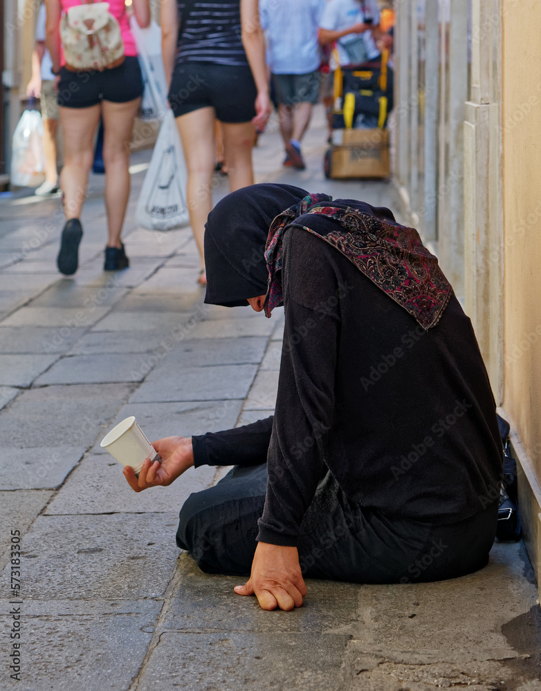 A homeless female beggar is begging on the street in Venice, Italy ...