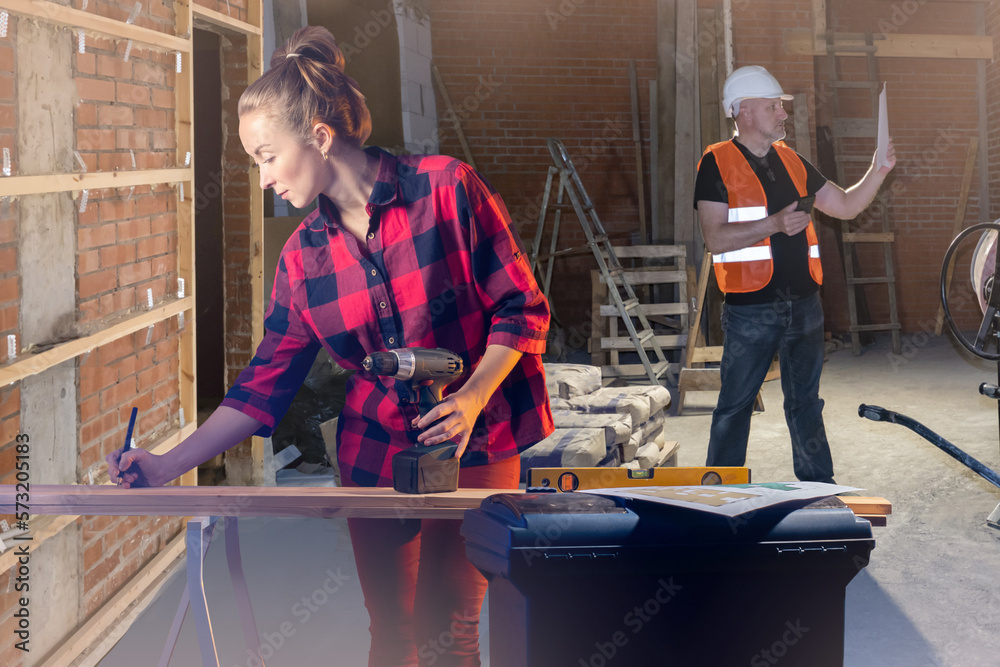 Woman works at construction site. Girl carpenter at construction site. Furniture maker makes ...