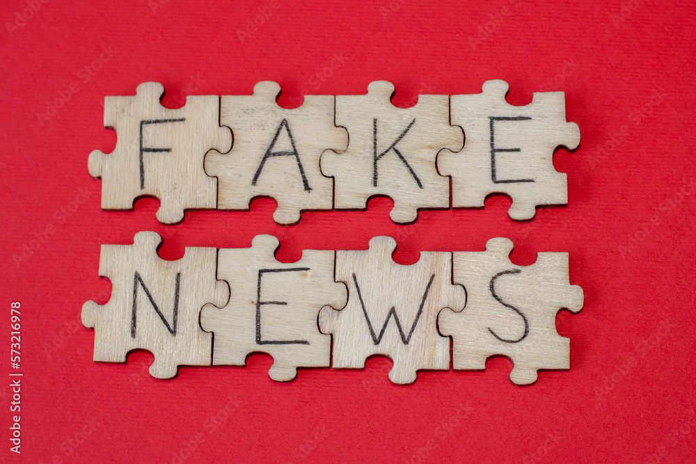 Wooden puzzles with Fake News on a red background. Misinformation ...