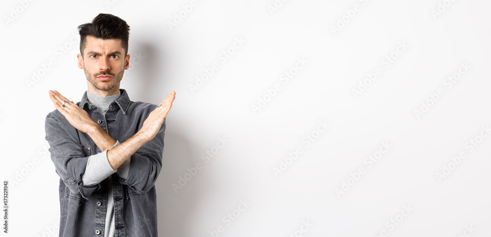Angry man show cross gesture to stop or say no, frowning and looking ...