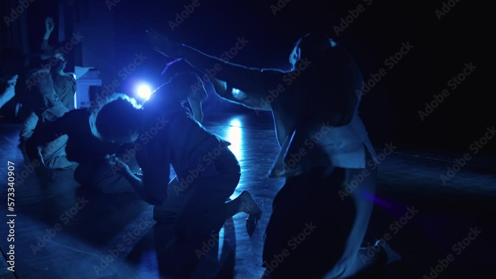 Girls dance in blue light and smoke. Young dancers perform on stage in ...