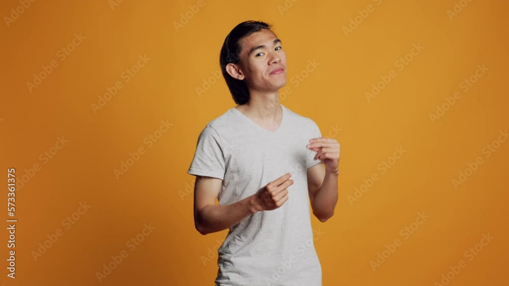 Cheerful guy showing groovy dance moves in studio, having fun dancing ...