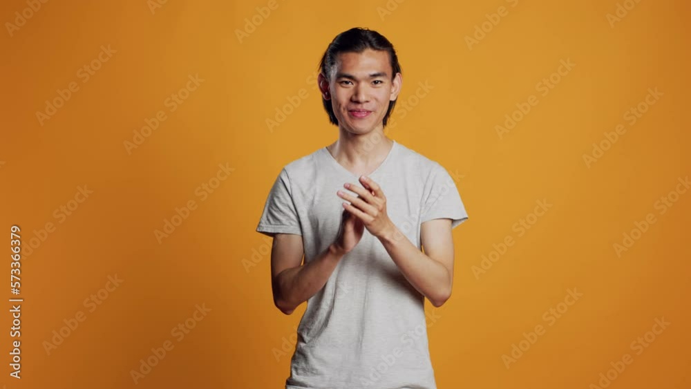 Smiling person clapping hands in studio, laughing and showing natural ...