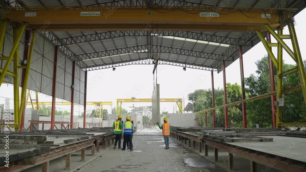 Engineers are inspecting work inside a precast concrete factory ...