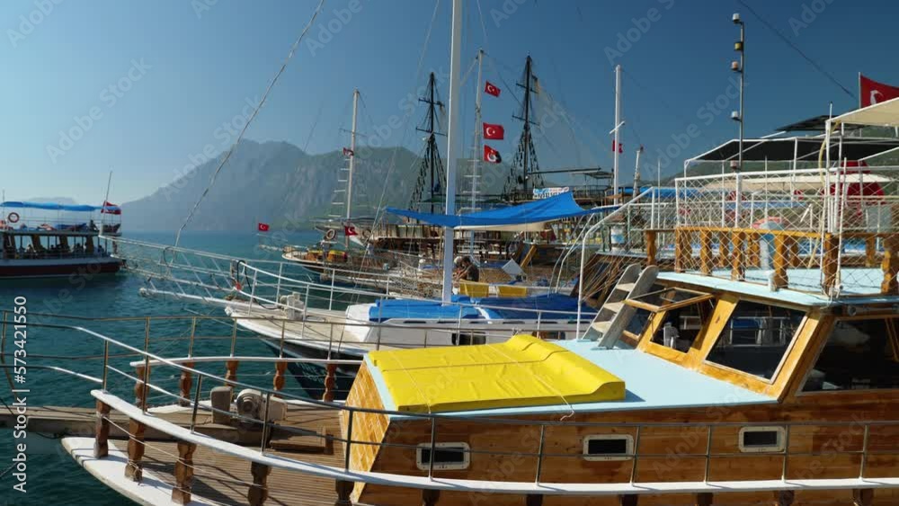 A view of a wooden pleasure boat with masts anchored off coast. Turkish ...