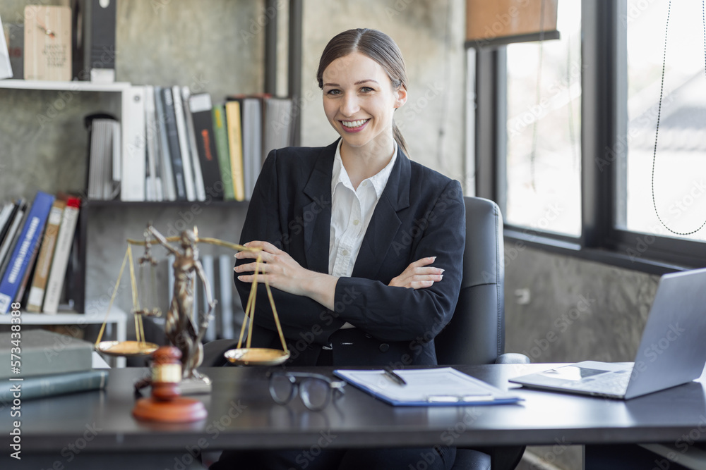 Statue of Justice and female lawyer in suit at workplace with laptop ...