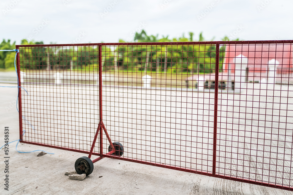 The mobile wheels on the red iron fence allow for easy movement. Stock ...