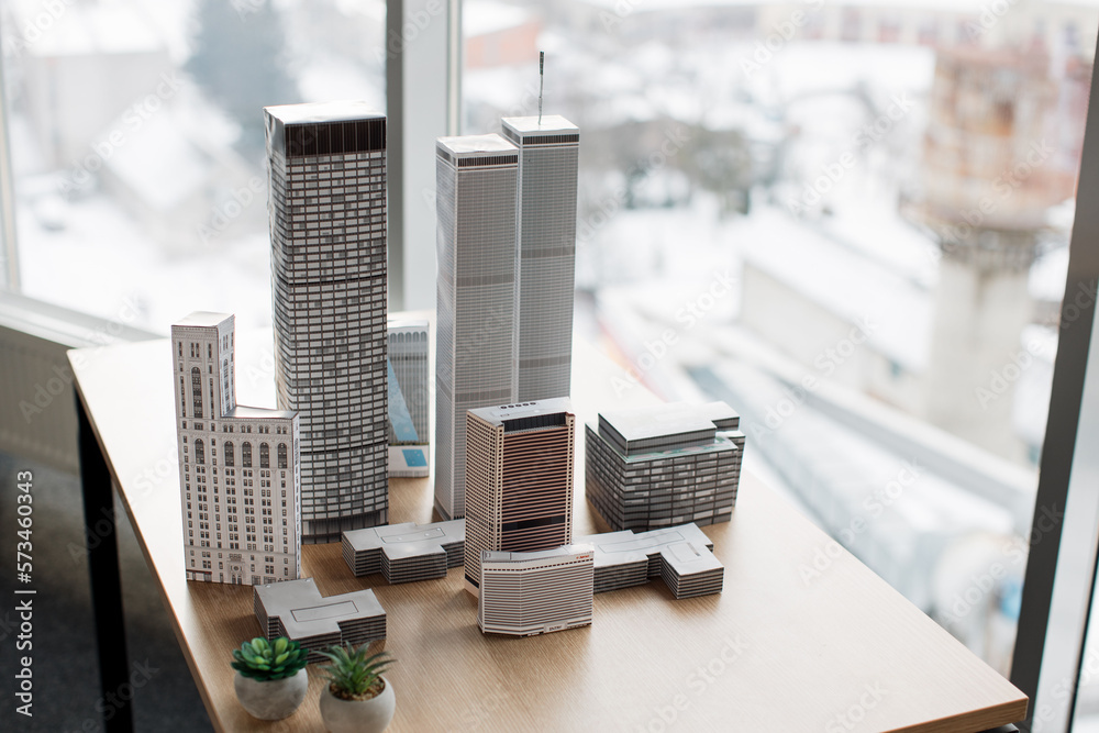 Table with white architectural scale cardboard model of building ...