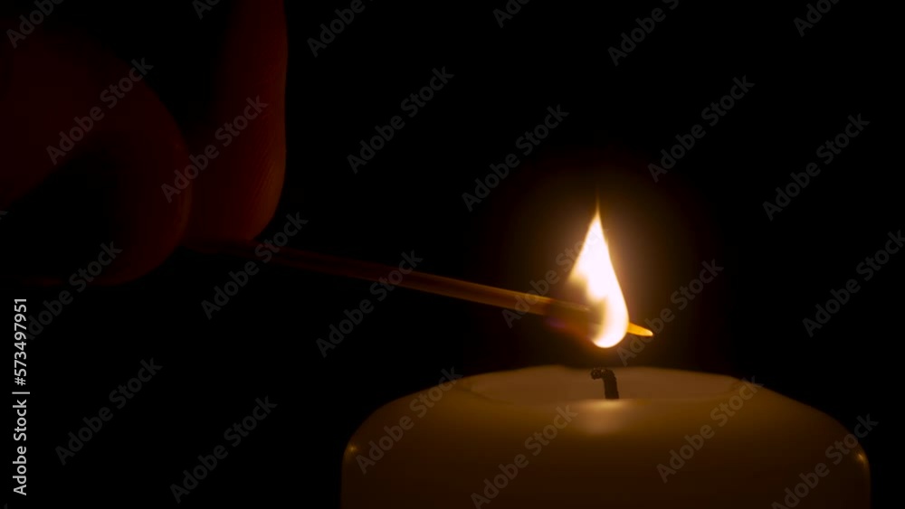 Large candle is lit close up with match fire flame. Lifestyle ...