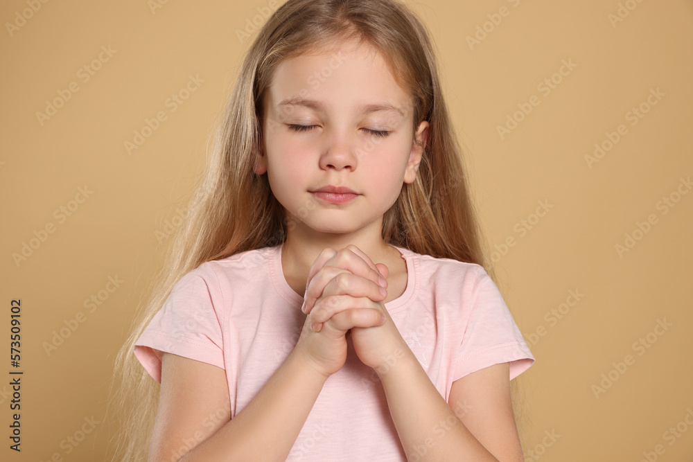 Girl with clasped hands praying on beige background Stock Photo | Adobe ...