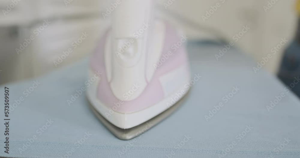 Zoom in iron nose to the camera. Concept of successful ironing, a woman ...