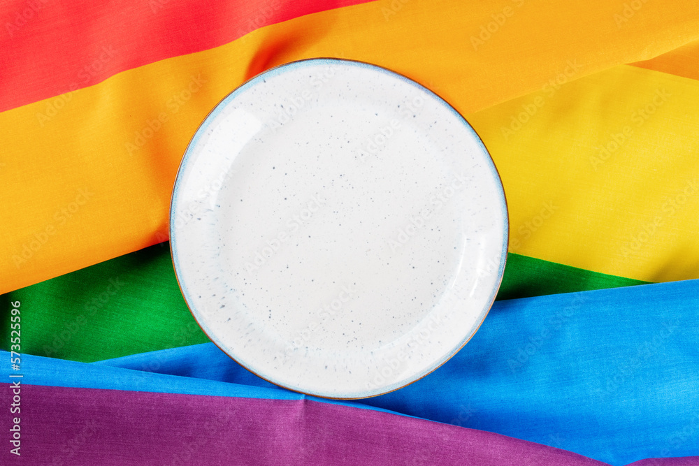 Gay food concept. A plate, overhead flat lay shot on the LGBTQ rainbow ...