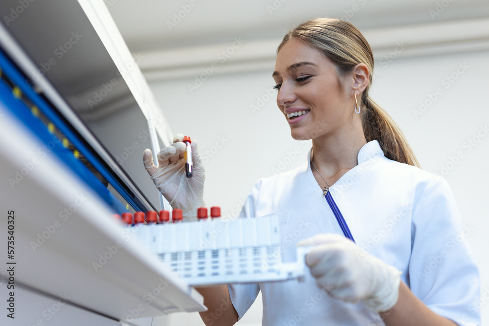 Lab tech loading samples into a chemistry analyzer. female lab tech ...