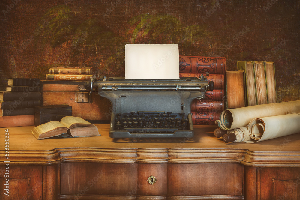 Old wooden desk with vintage typewriter holding an empty sheet of paper ...