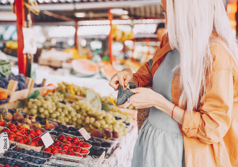 Young woman buying organic fruits and berries in local market. Customer ...