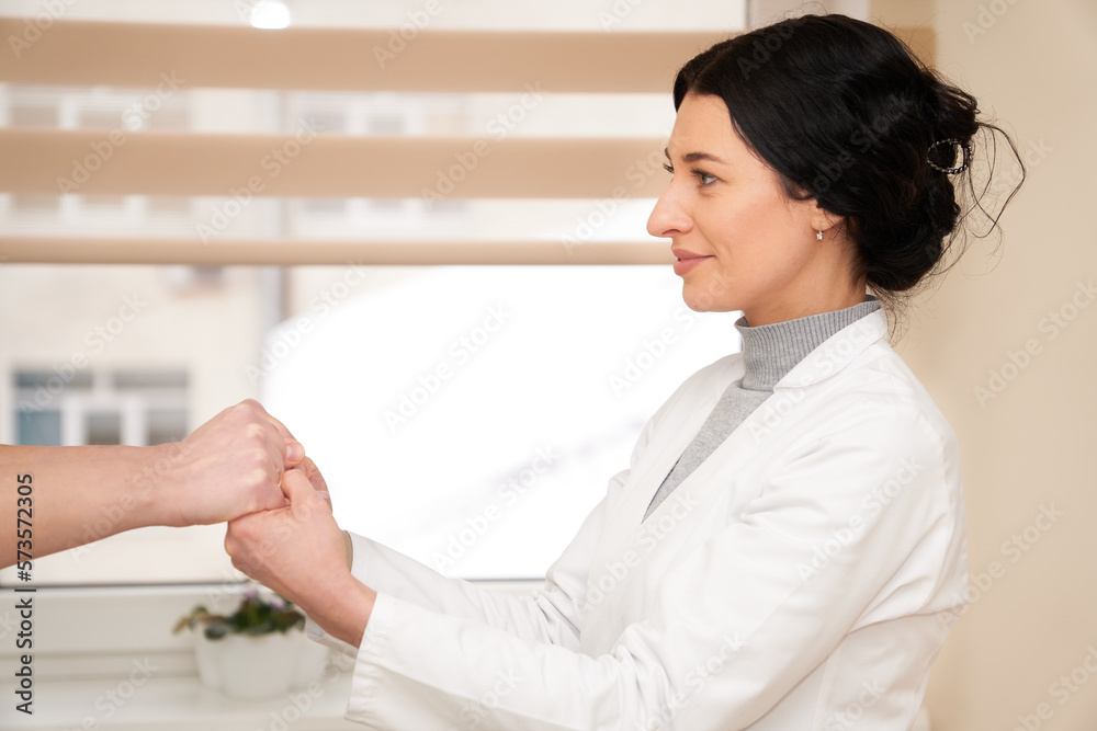 Doctor neurologist checking reflexes of female patient with percussion ...